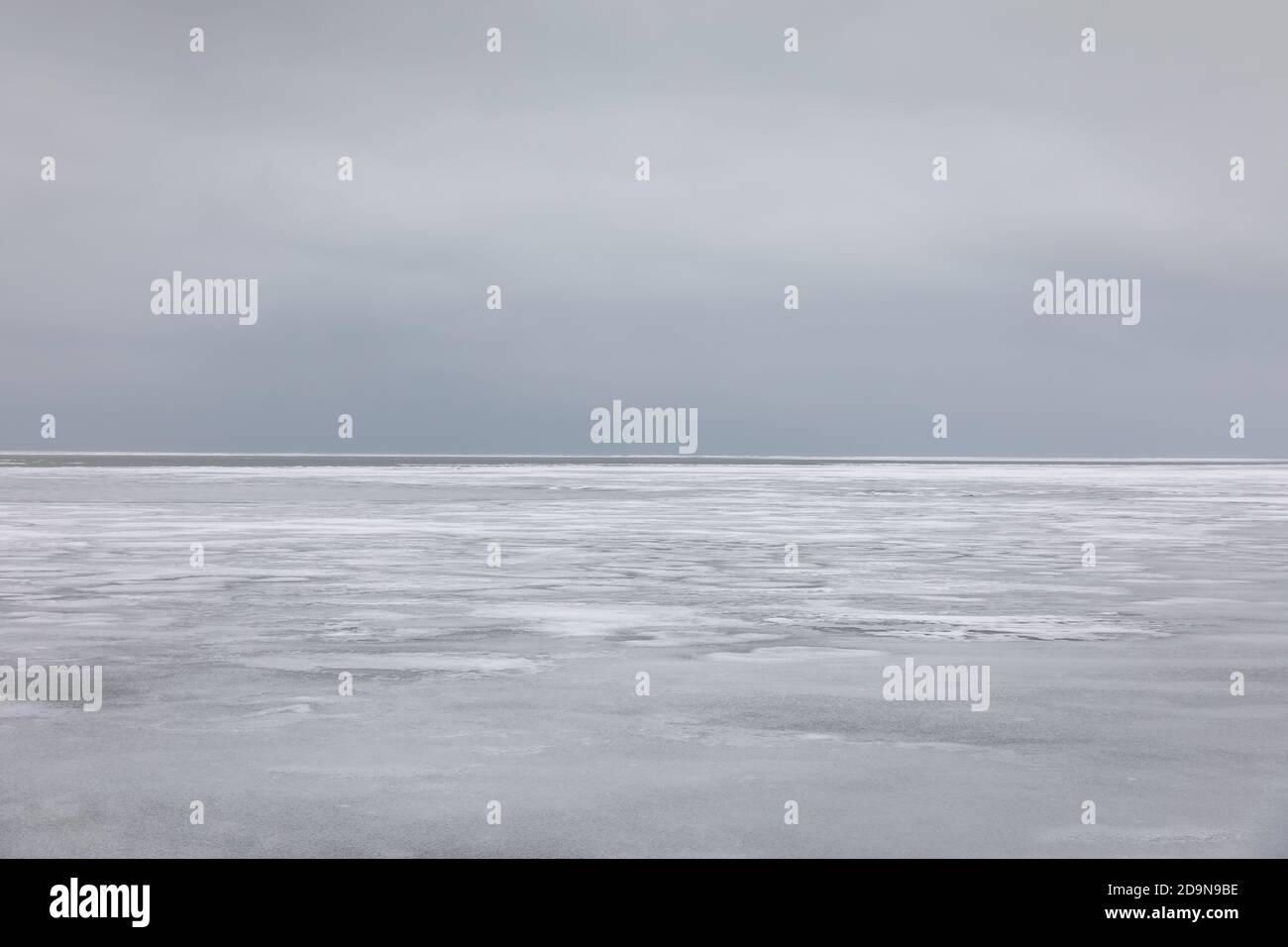 Nature background. Frozen sea water and gray sky over horizon ...