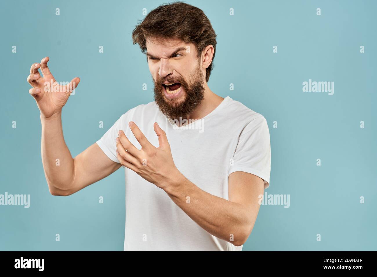 Man gestures with his hands emotions displeasure white t-shirt blue ...