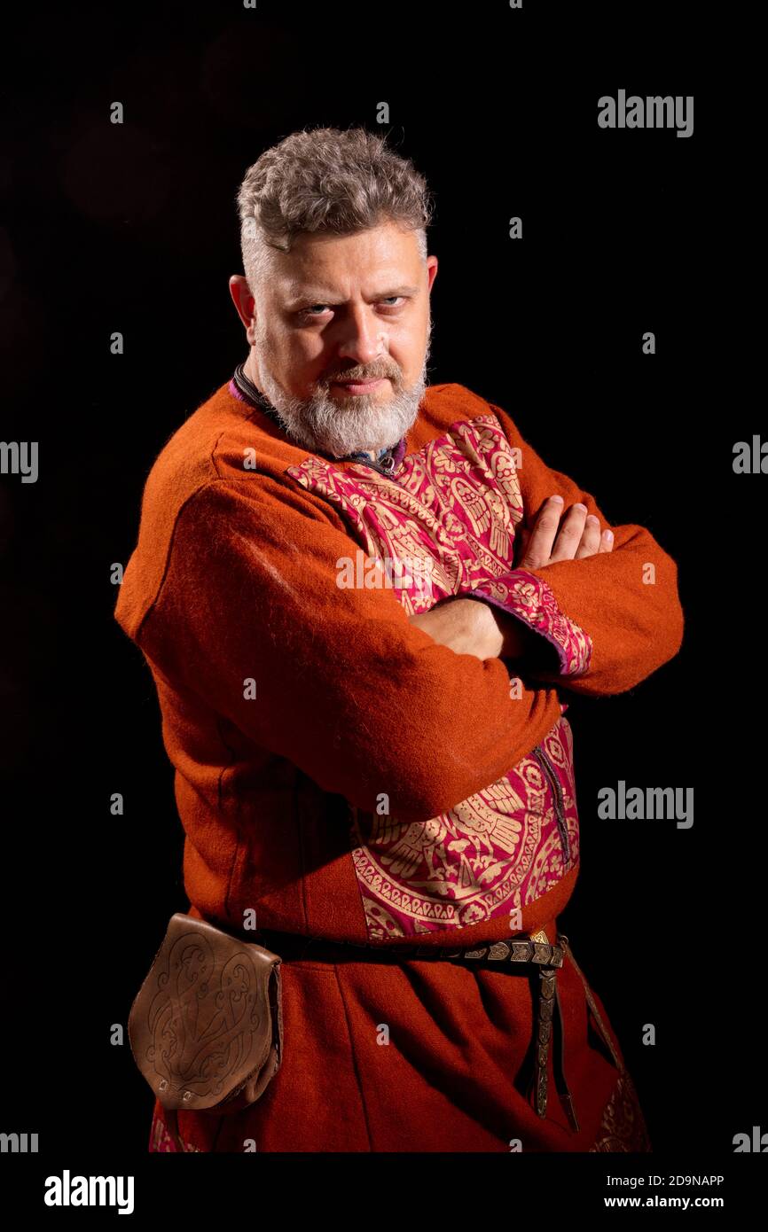 Mature bearded man in traditional historic clothes studio portrait ...