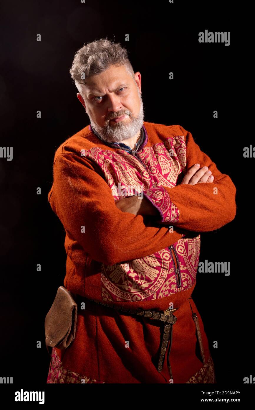 Mature bearded man in traditional historic clothes studio portrait ...