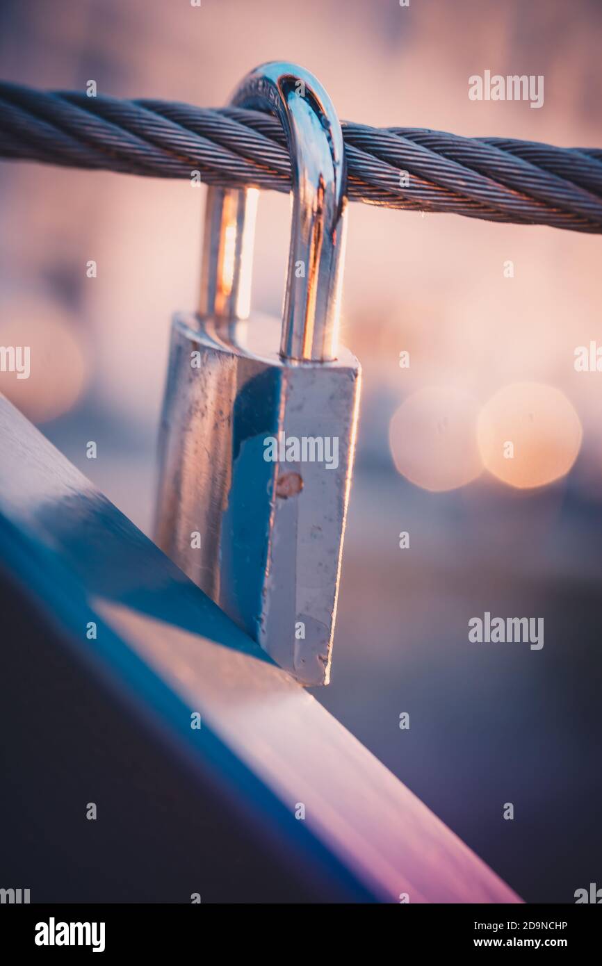 close-up of a padlock hanging on a wire on a bridge in the old harbor ...