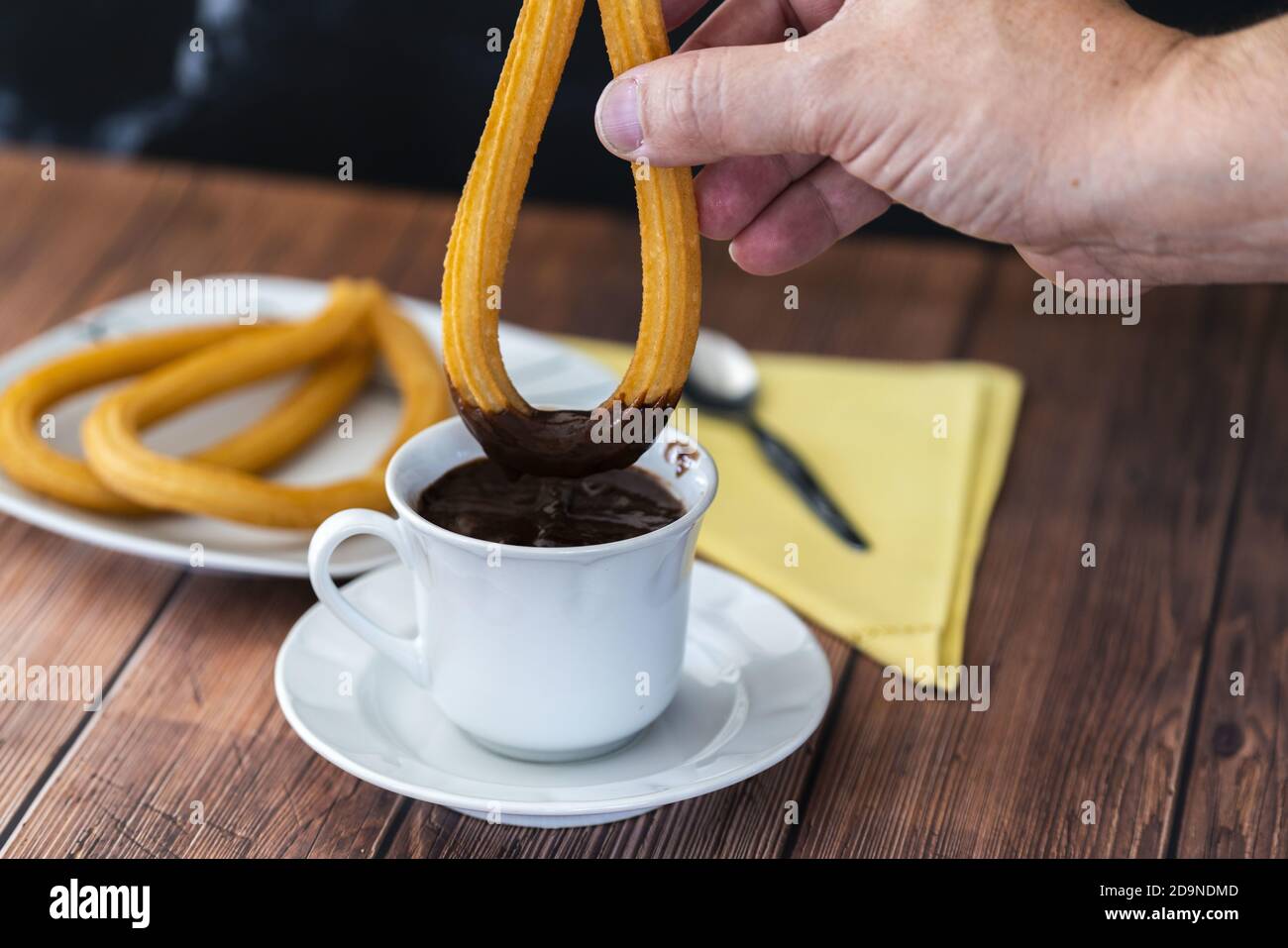 Hand dipping churros in hot chocolate Stock Photo - Alamy