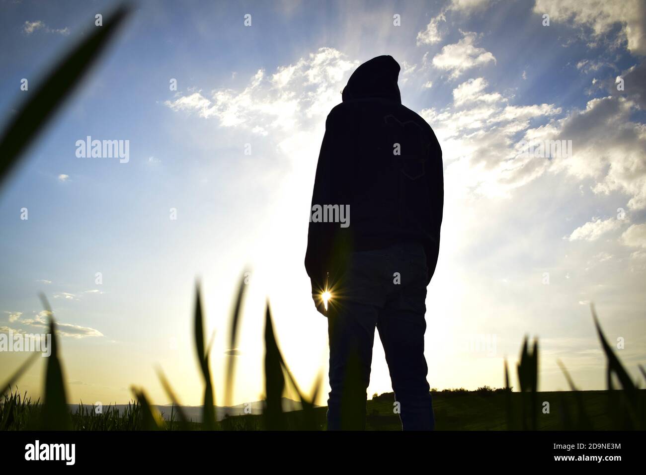 Mesmerizing shot of a male in a black hoody standing and looking to the ...