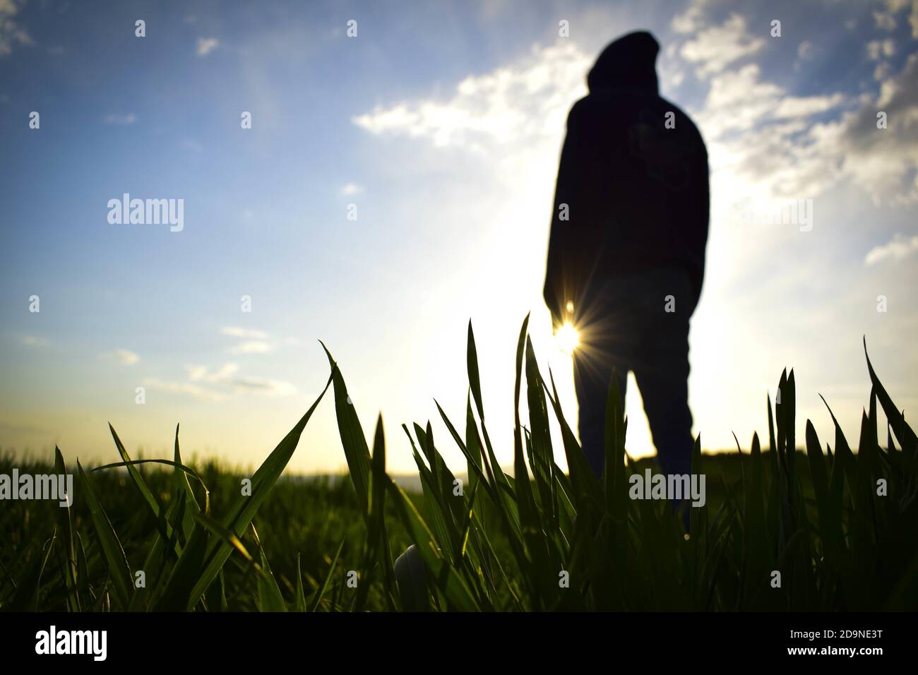Mesmerizing shot of a male in a black hoody standing and looking to the ...
