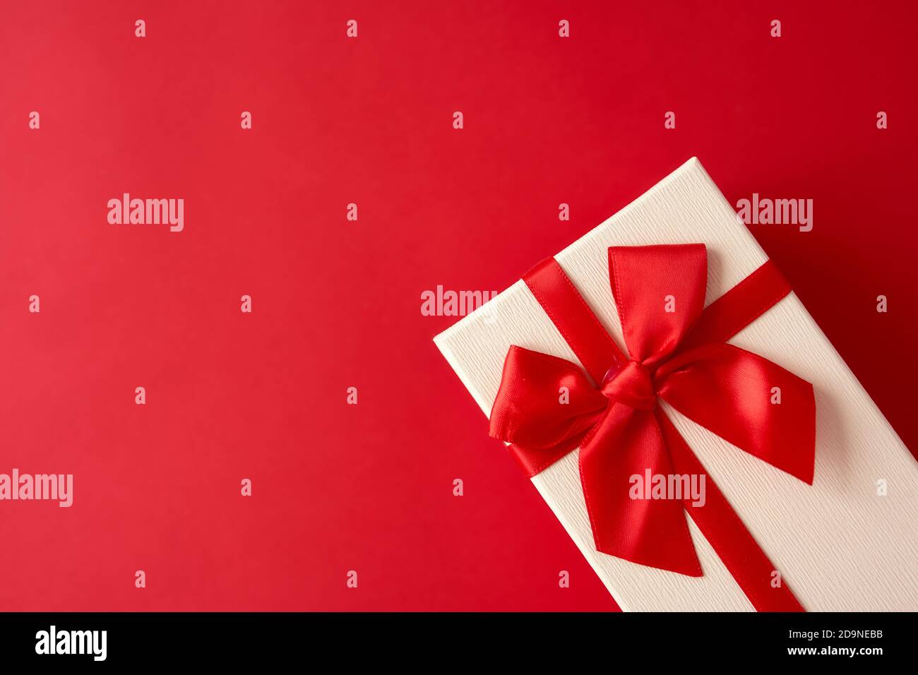 White present with red ribbon on the bright red background Stock Photo ...