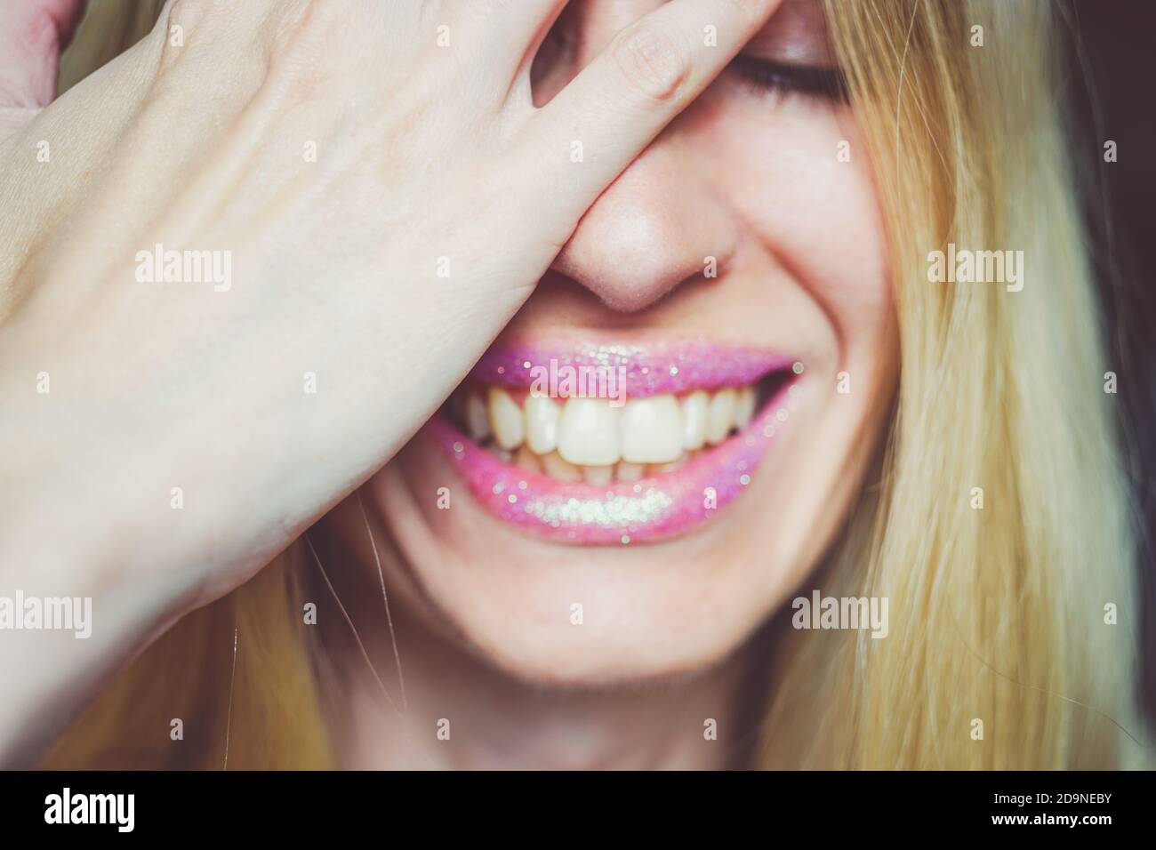 Happy young girl laughs, covering part of her face with her hand Stock ...