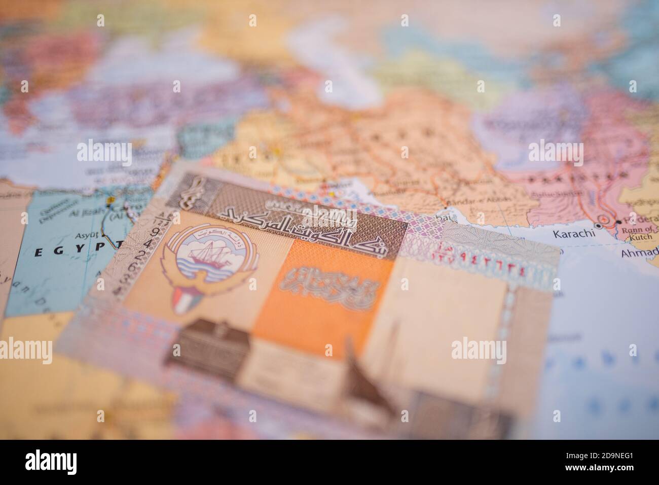 Kuwait Quarter Dinar bill below Kuwait on a colorful and blurry map ...