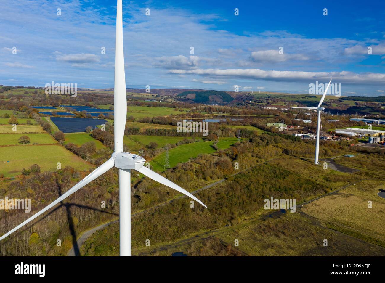 Aerial View of 2 large wind turbine stationary on beautiful welsh ...