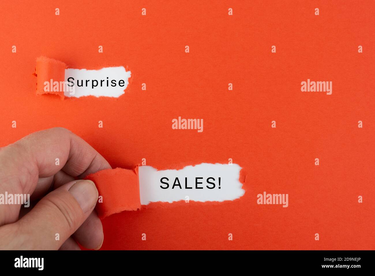Torn paper with the words surprise and sales underneath Stock Photo - Alamy