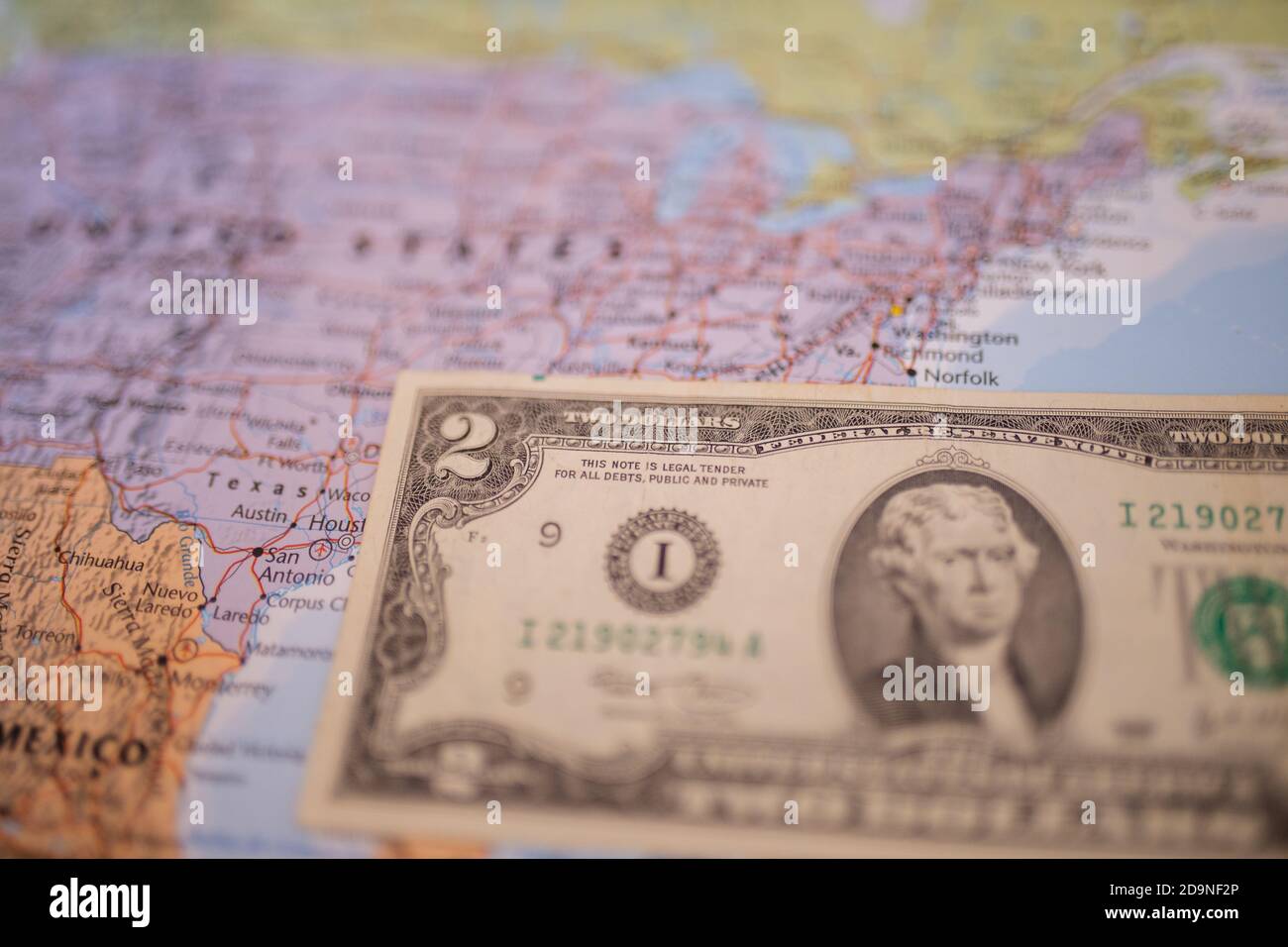 Two-dollar bill next to The United States of America on a colorful map ...