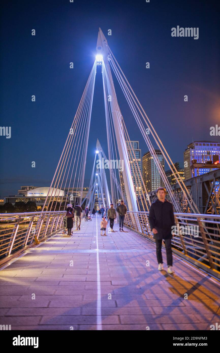 Pedestrians walking on a white bridge above the River Thames during ...