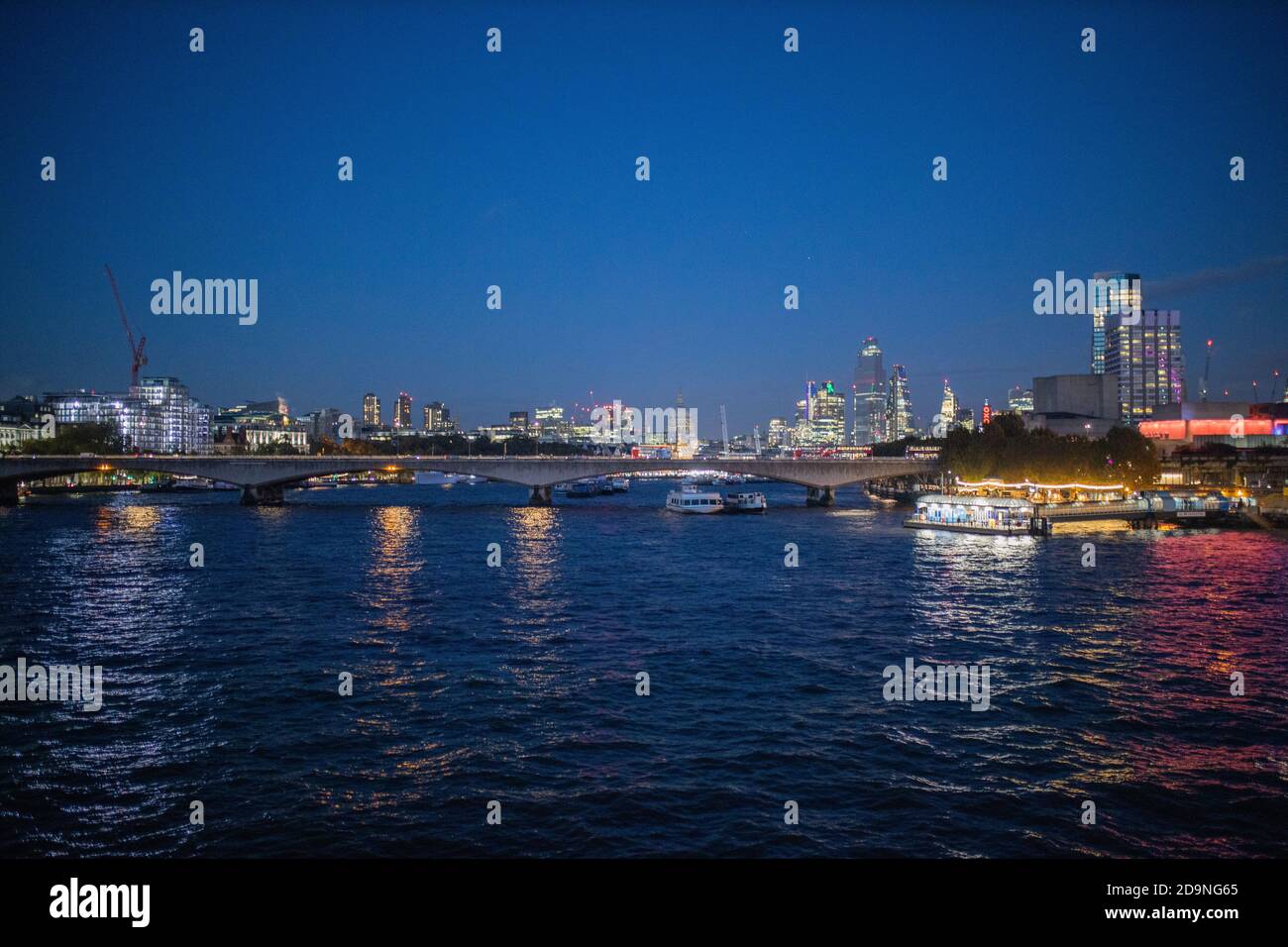River Thames at night and with the lights of the city reflecting on the ...