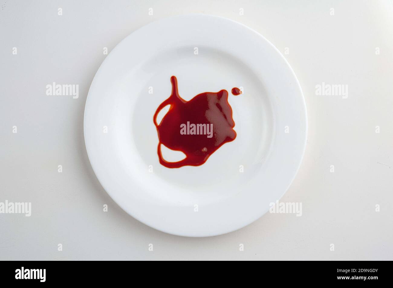 Top view shot of a ketchup splash on a plate on a white surface Stock ...