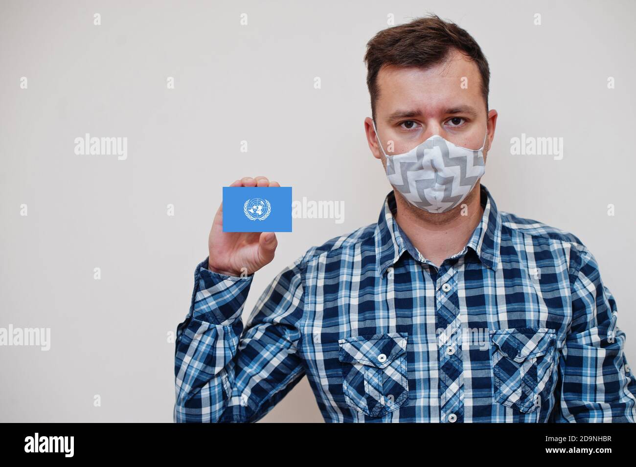 Man in checkered shirt show United Nations flag card in hand, wear ...