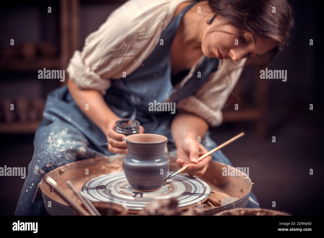 Beautiful potter female student creates a new pottery from clay on a ...