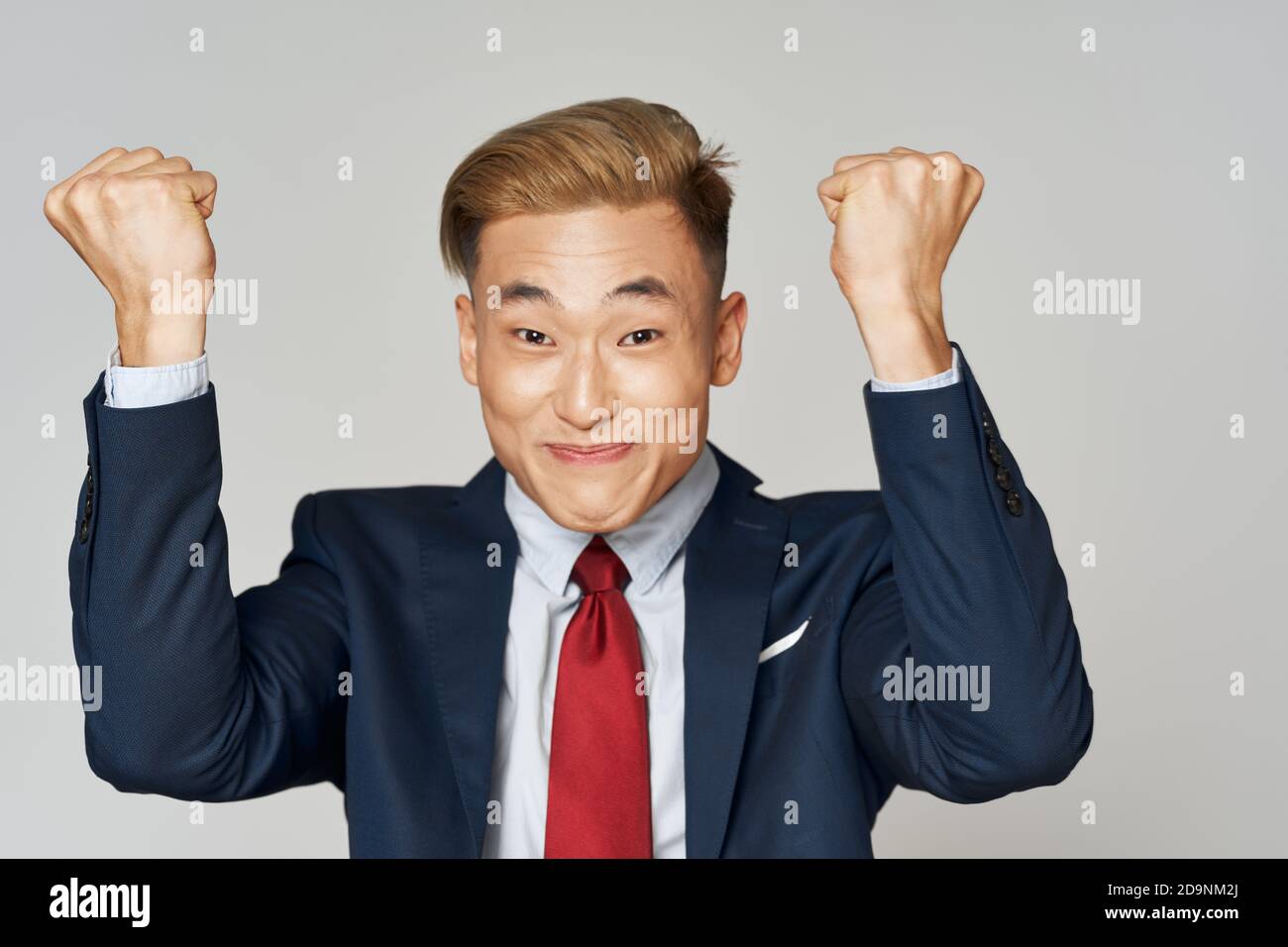 Business man wearing suit holds hands in front of him success joy ...