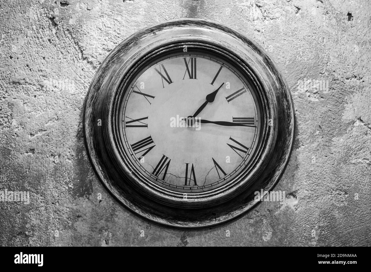 Ancient clock on an old cement wall background. Black and white Stock ...