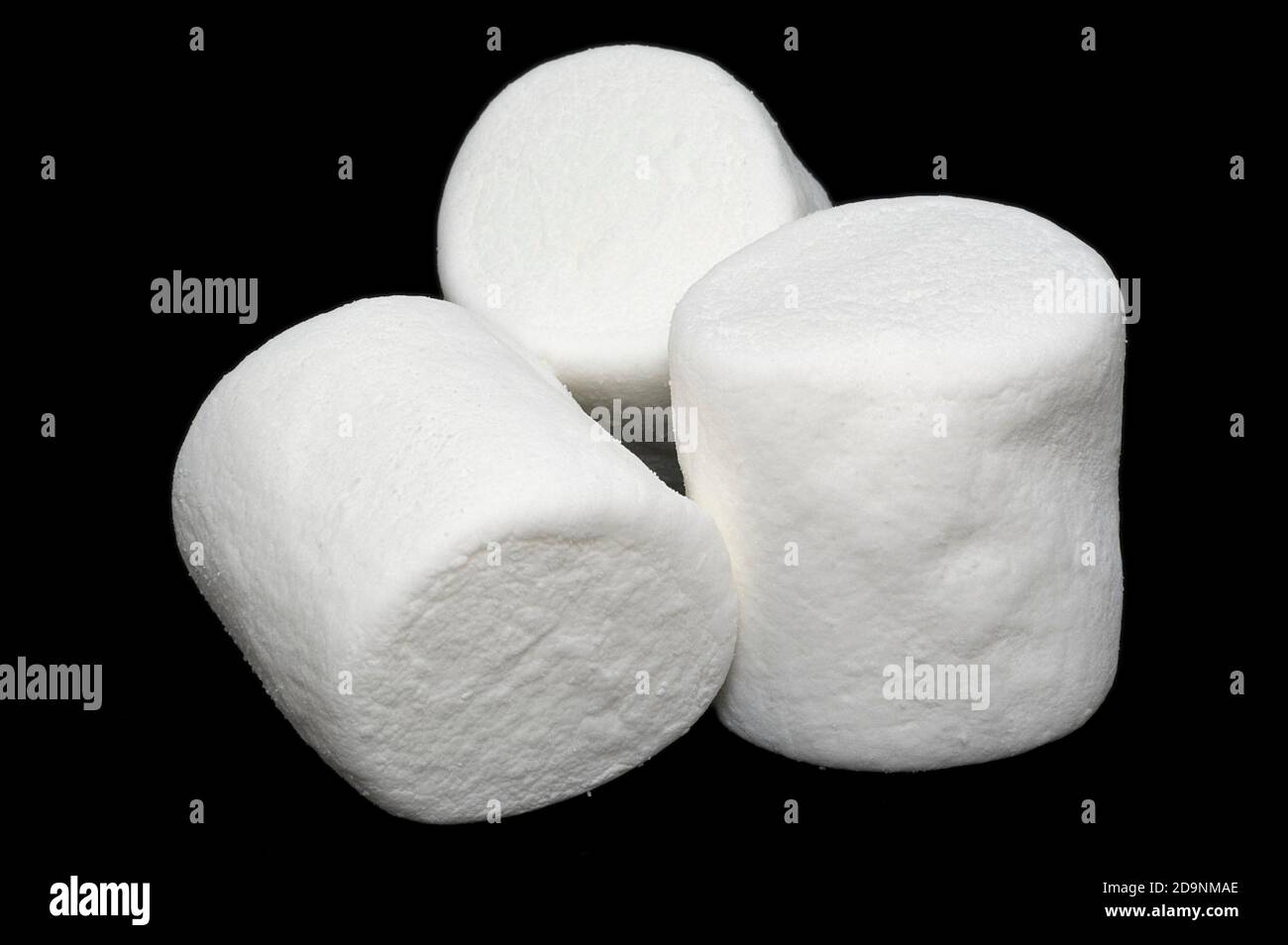 Three marshmallows isolated on a black background Stock Photo - Alamy