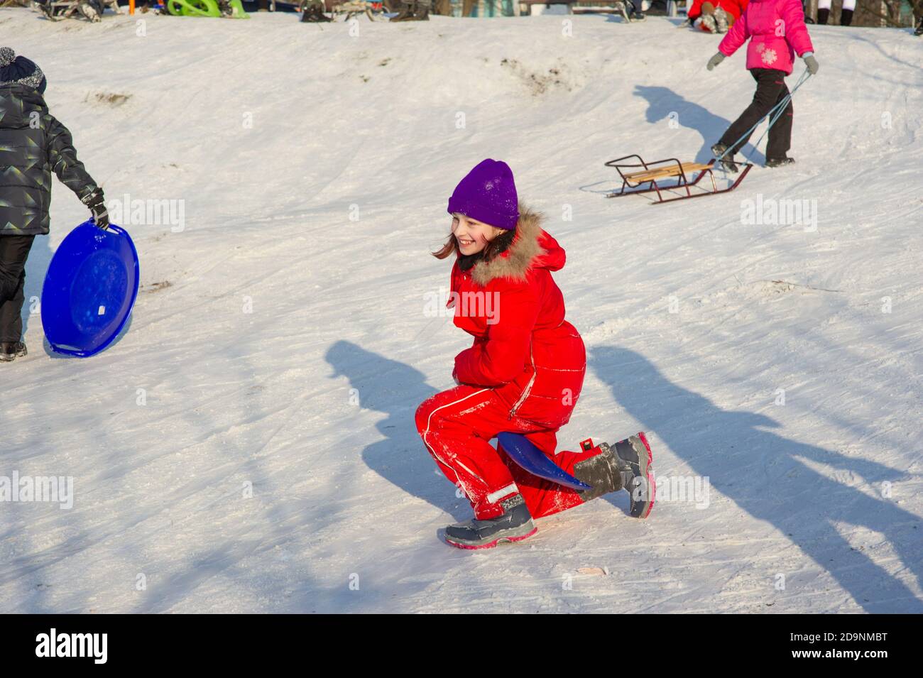 Little teenager girl in beautiful warm red outfit playing outdoors in ...