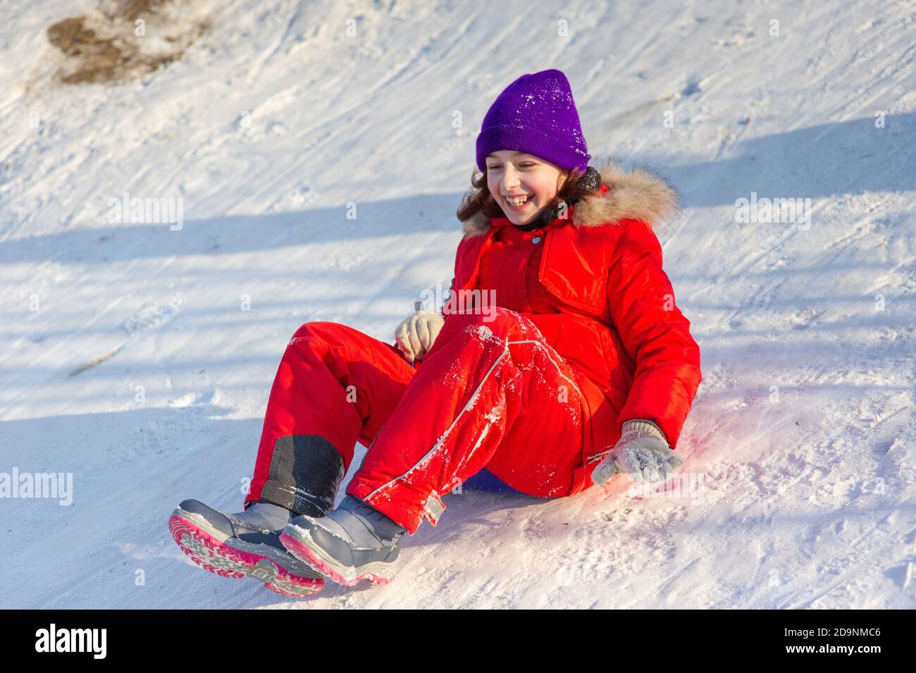 Little teenager girl in beautiful warm red outfit playing outdoors in ...