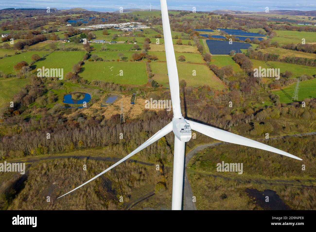 Aerial View of large wind turbine stationary on beautiful welsh ...