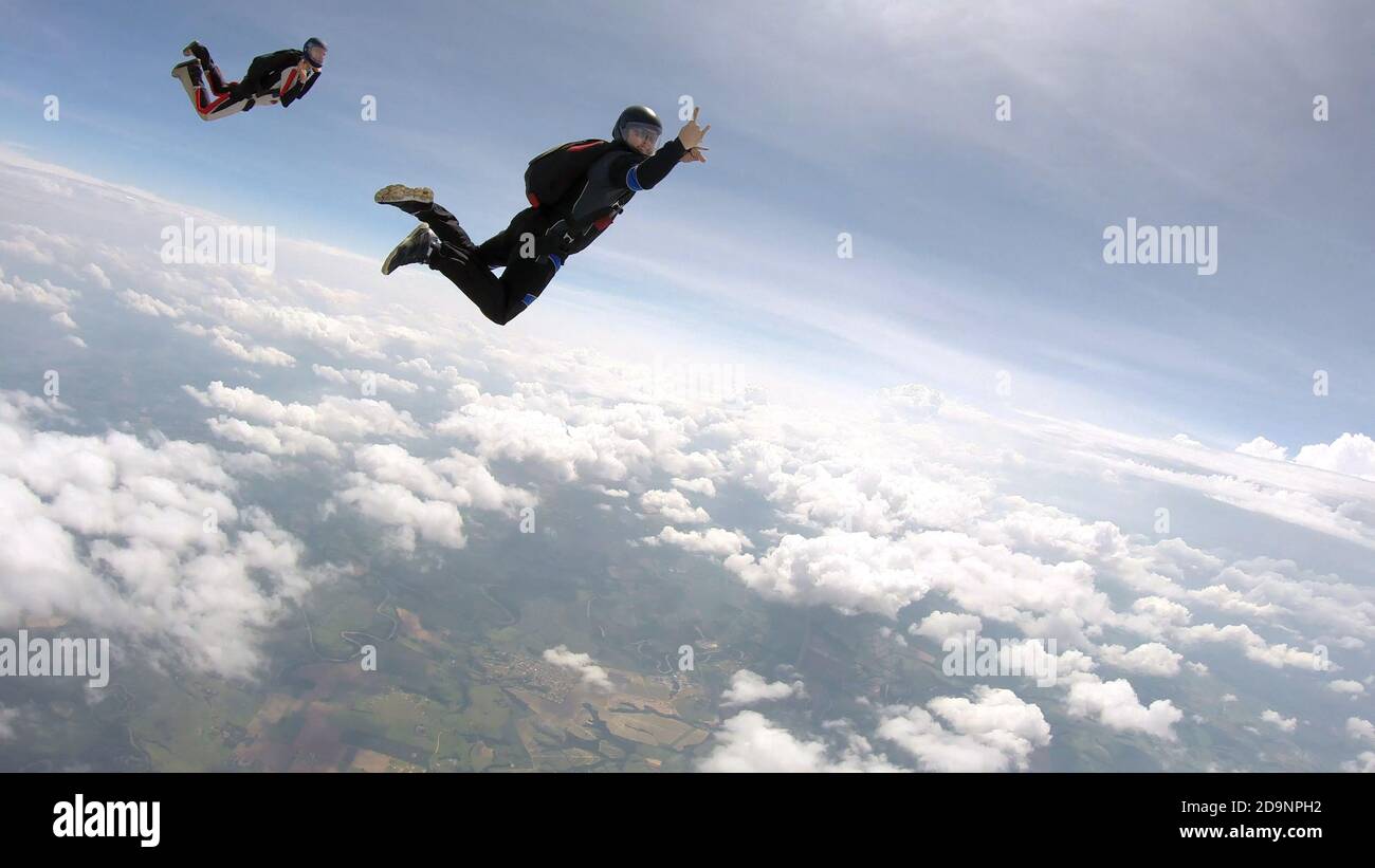 A group of friends holding hands teamwork in skydiving, soft focus on ...