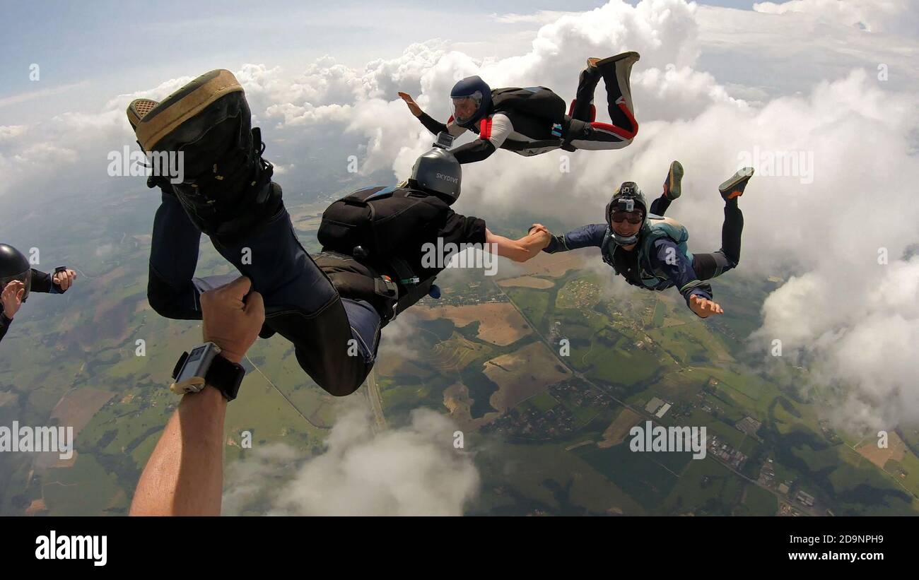 A group of friends holding hands teamwork in skydiving, soft focus on ...