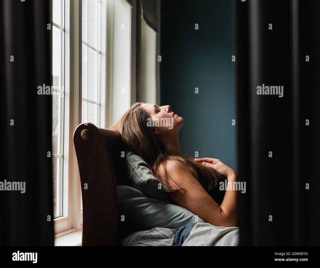 Mirror reflection of woman laying on a bed in a dark bedroom Stock ...