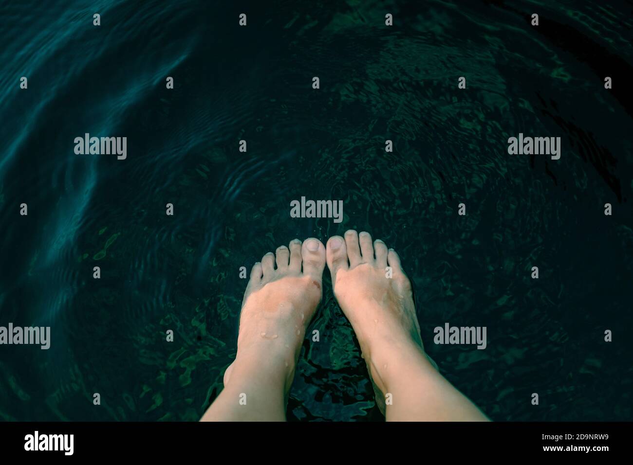 Woman's feet in river water Stock Photo - Alamy