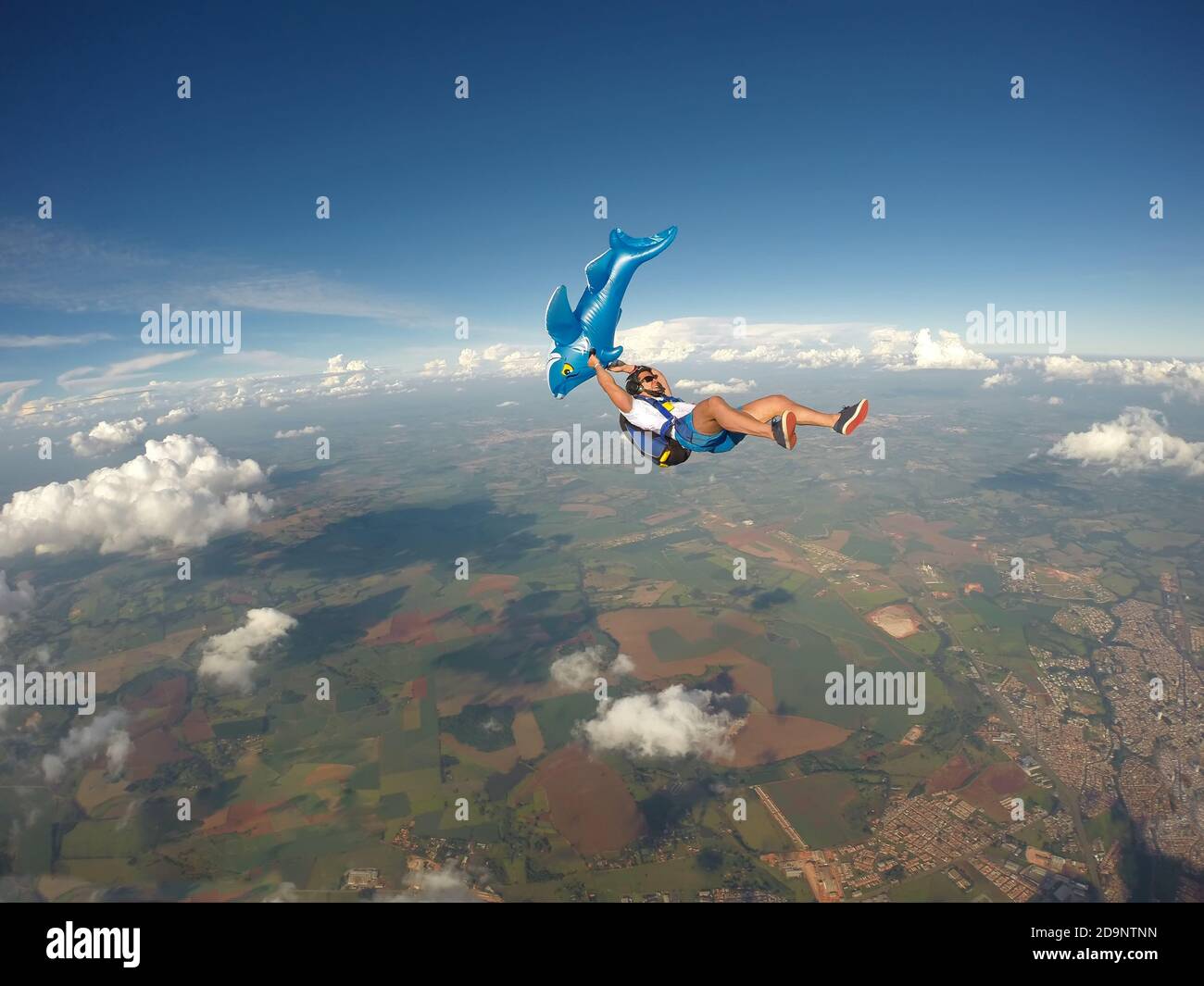 Parachutist holding an inflatable shark in free fall Stock Photo - Alamy