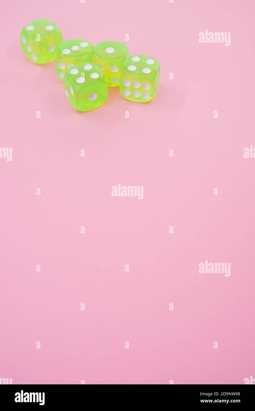 A closeup of five neon green dice isolated on a pink background Stock ...