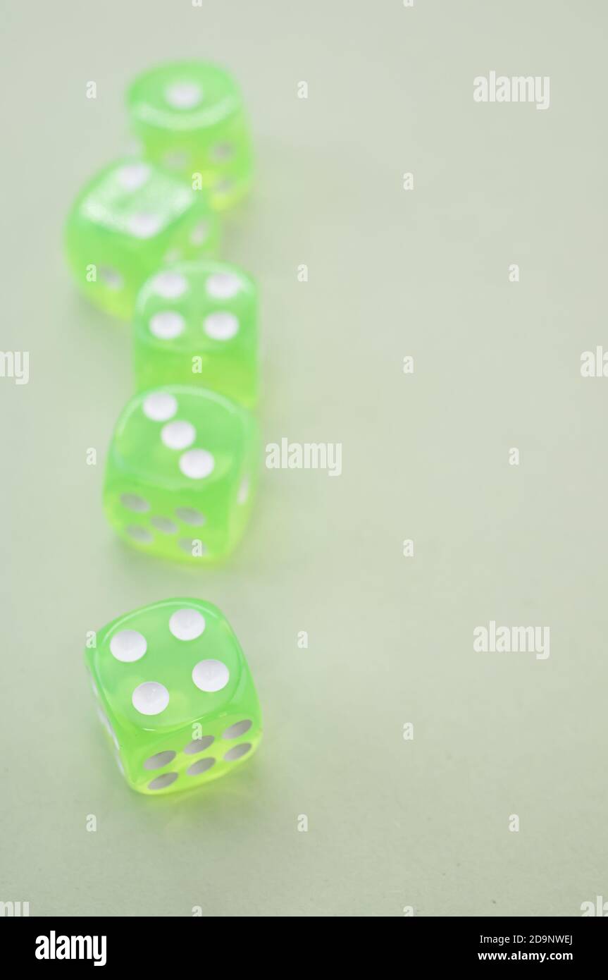 A top view closeup of five neon green dice isolated on a grey ...