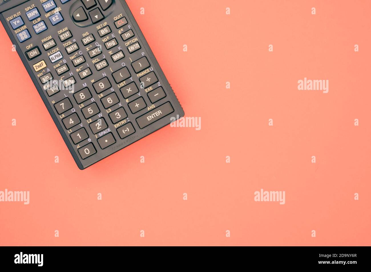 A top view closeup of a graphing calculator isolated on a bright pink ...