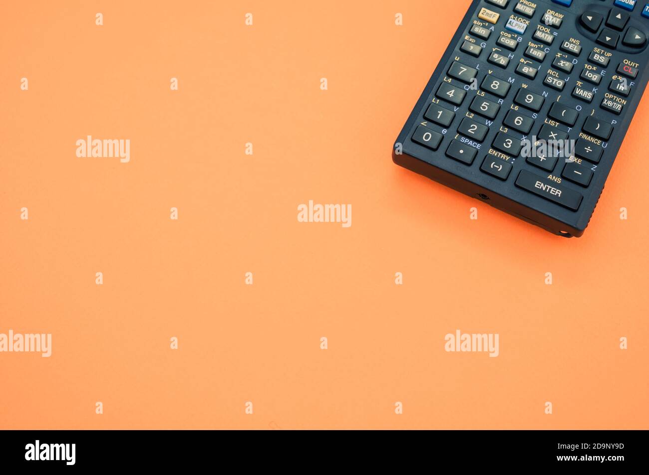 A top view closeup of a graphing calculator isolated on an orange ...
