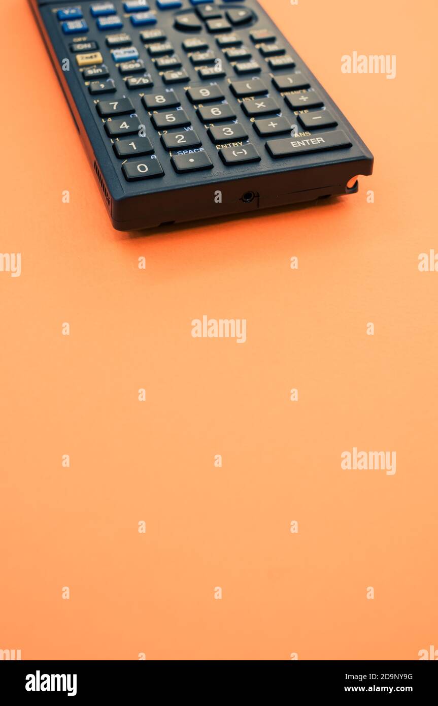 A top view closeup of a graphing calculator isolated on an orange ...