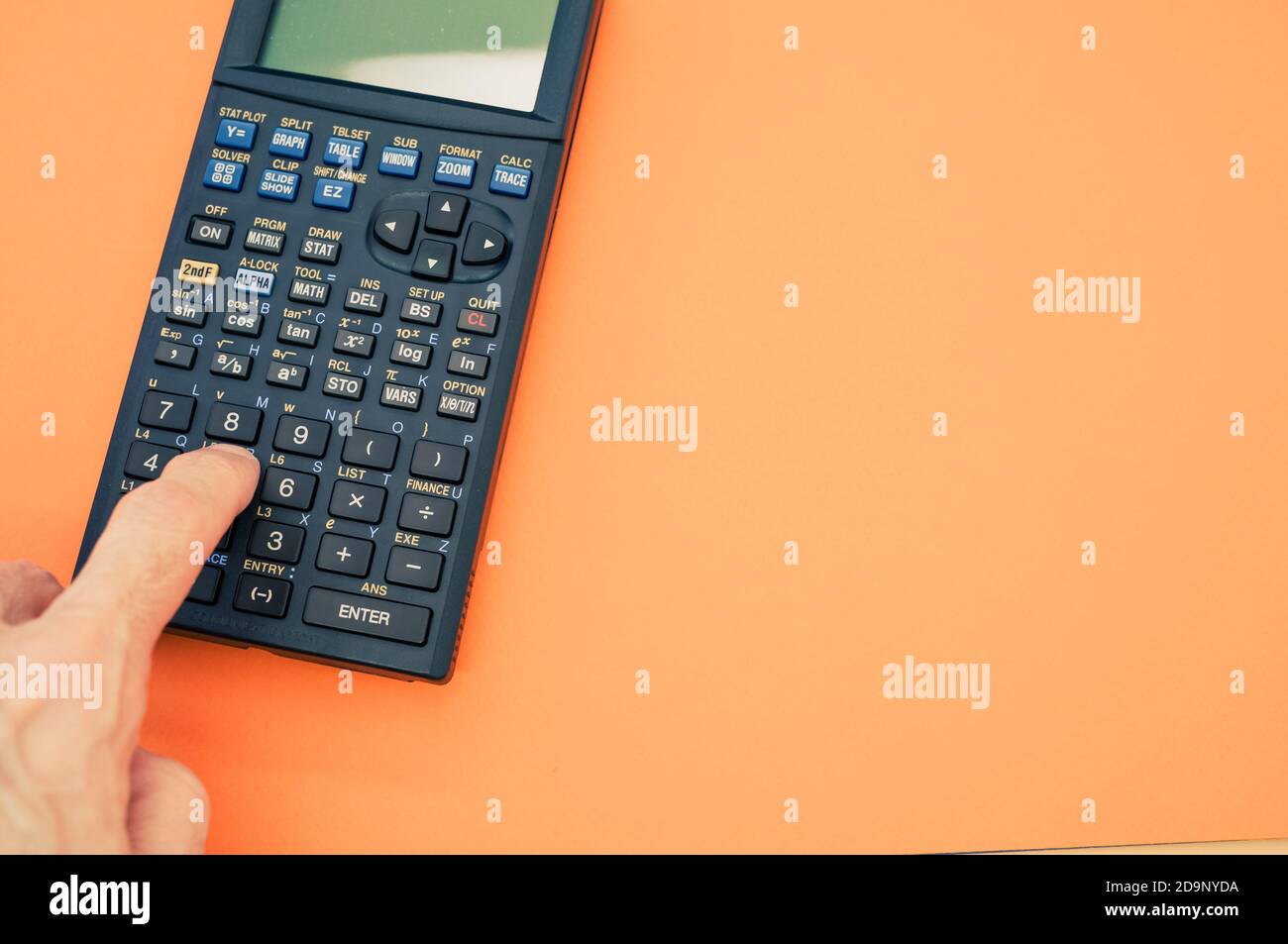 A top view closeup of a finger pressing buttons on a calculator ...