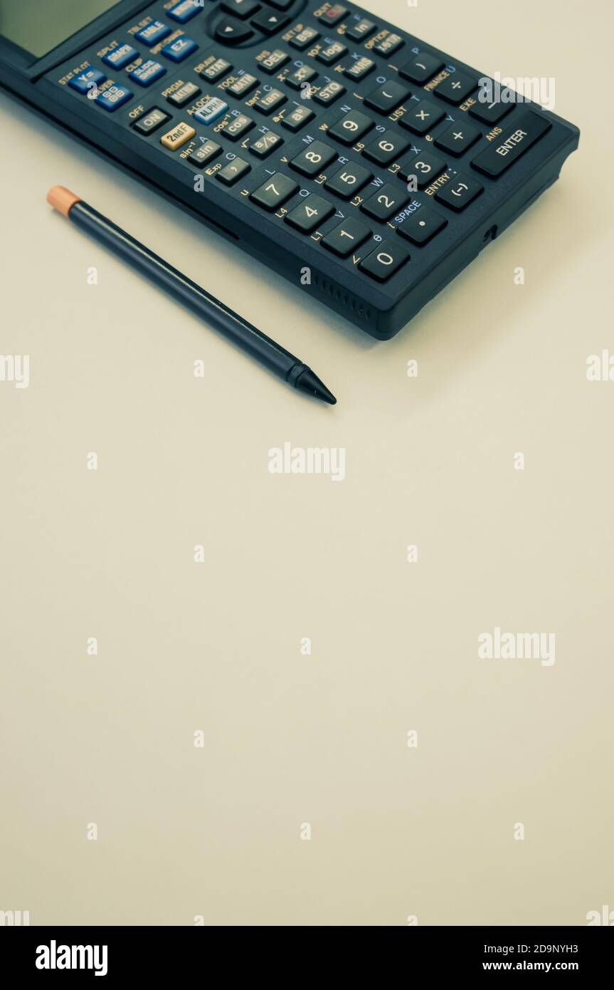 A top view closeup of a graphing calculator and a pen isolated on a ...