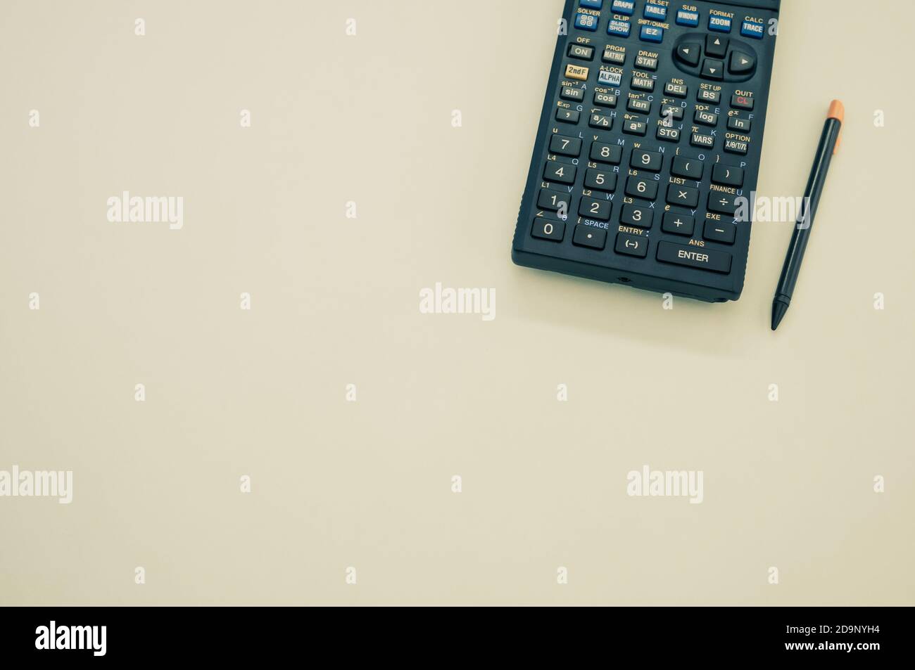 A top view closeup of a graphing calculator and a pen isolated on a ...