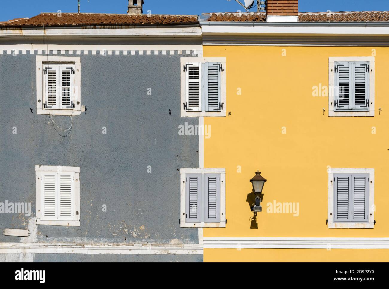 a half yellow half gray building with white windows Stock Photo - Alamy