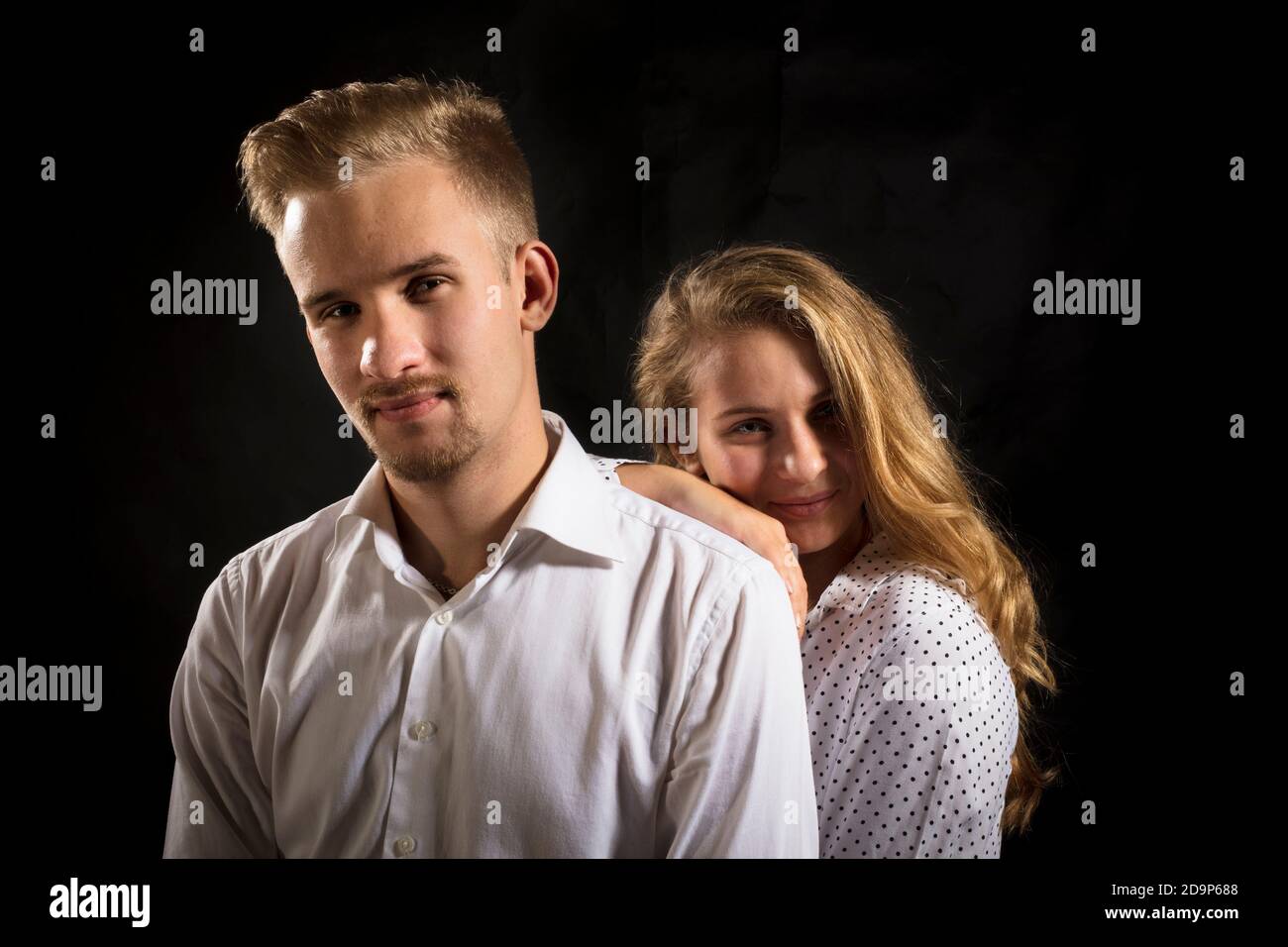 Young beautiful couple studio portrait on black background Stock Photo ...