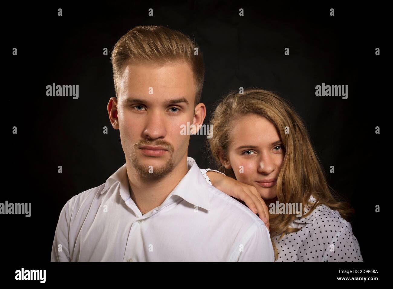Young beautiful couple studio portrait on black background Stock Photo ...