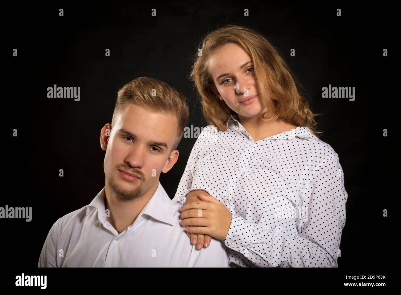 Young beautiful couple studio portrait on black background Stock Photo ...
