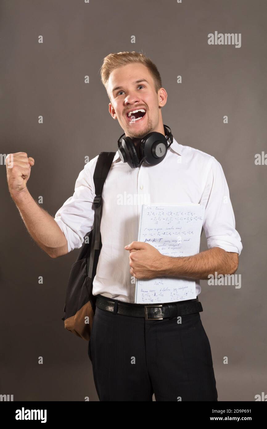 Young student dressed in white shirt is happy that he succesfully ...