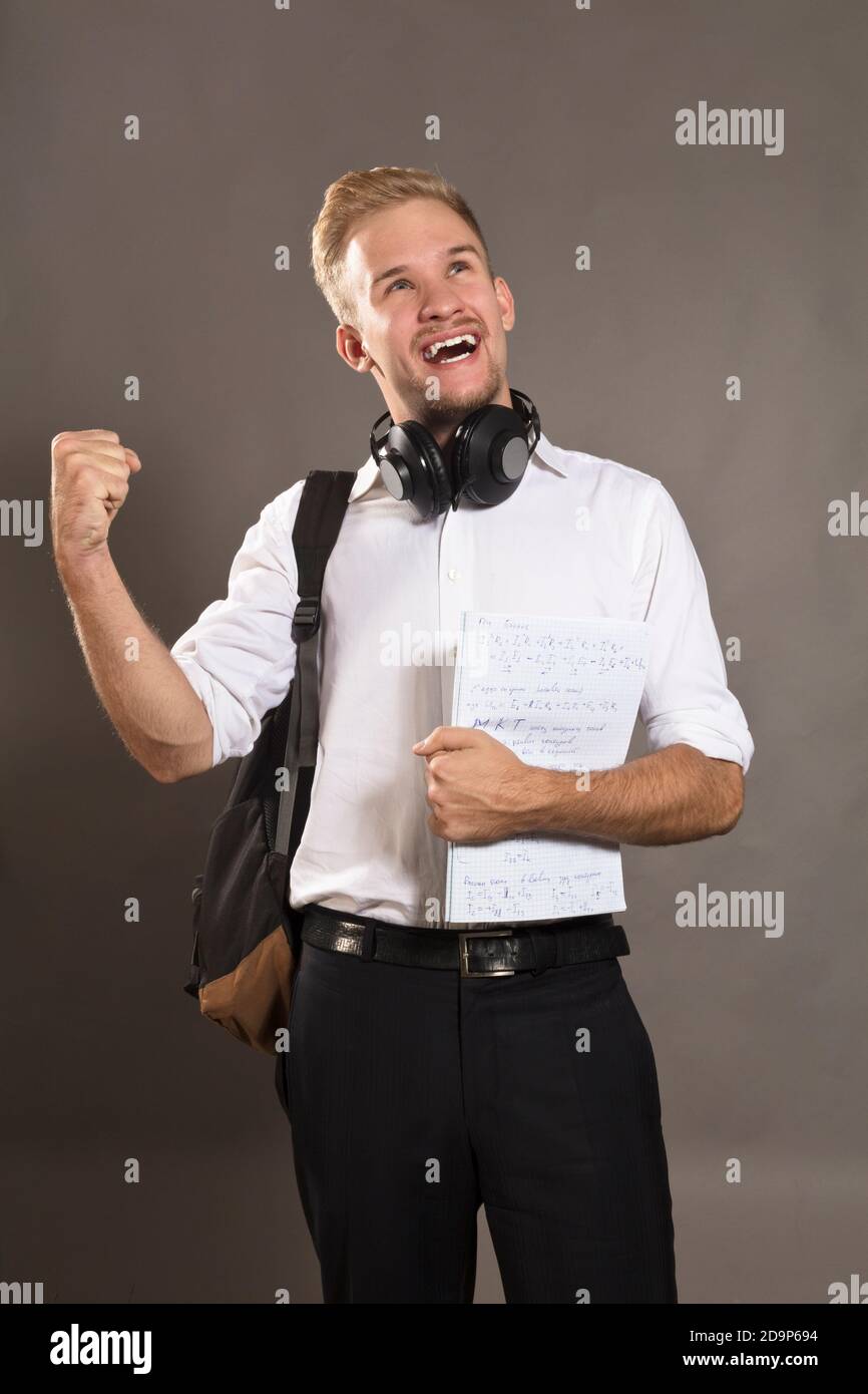 Young student dressed in white shirt is happy that he succesfully ...