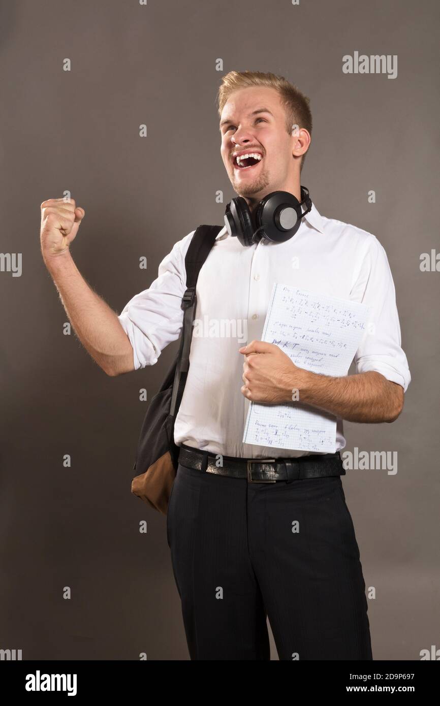 Young student dressed in white shirt is happy that he succesfully ...