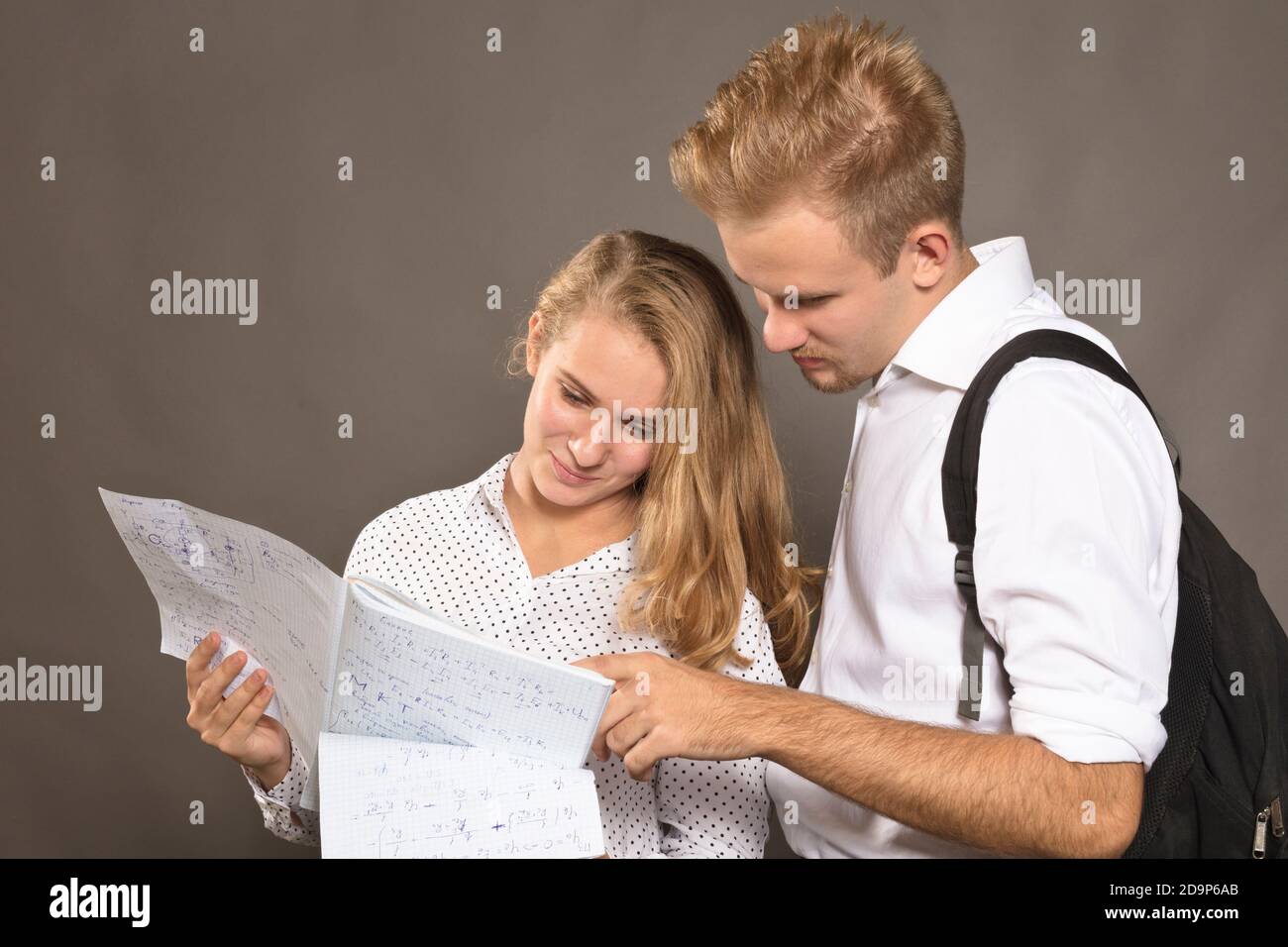 Two students young man and woman watching papers studio portrait Stock ...