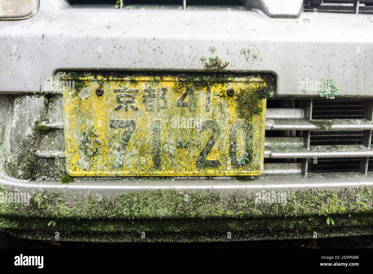Dirty number plate on a dilapidated abandoned Japanese Mitsubishi ...