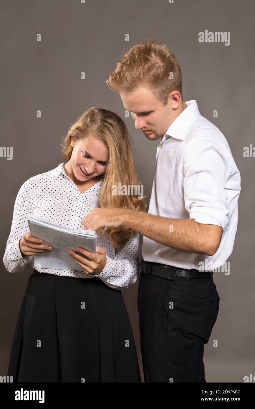 Two students young man and woman watching papers studio portrait Stock ...