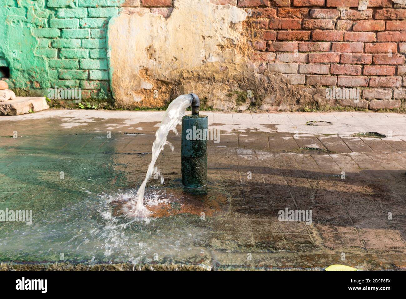 View of water overflowing onto the street from a water hydrant on the ...