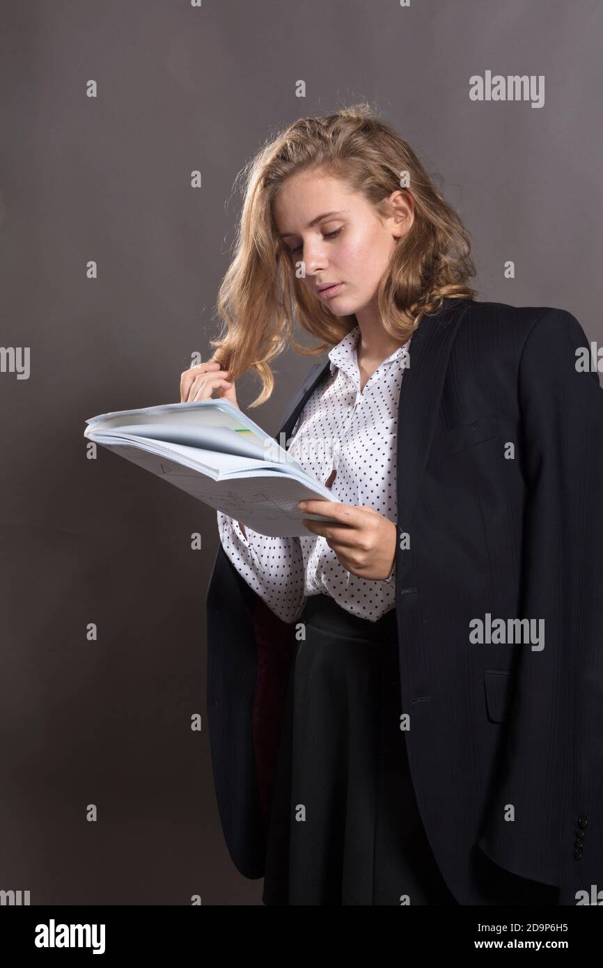 Young beautiful longhaired college girl with papers and jacket on her ...
